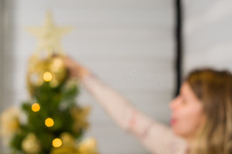 Great Concept of Christmas Woman Putting Star on Christmas Tree. Blured ...