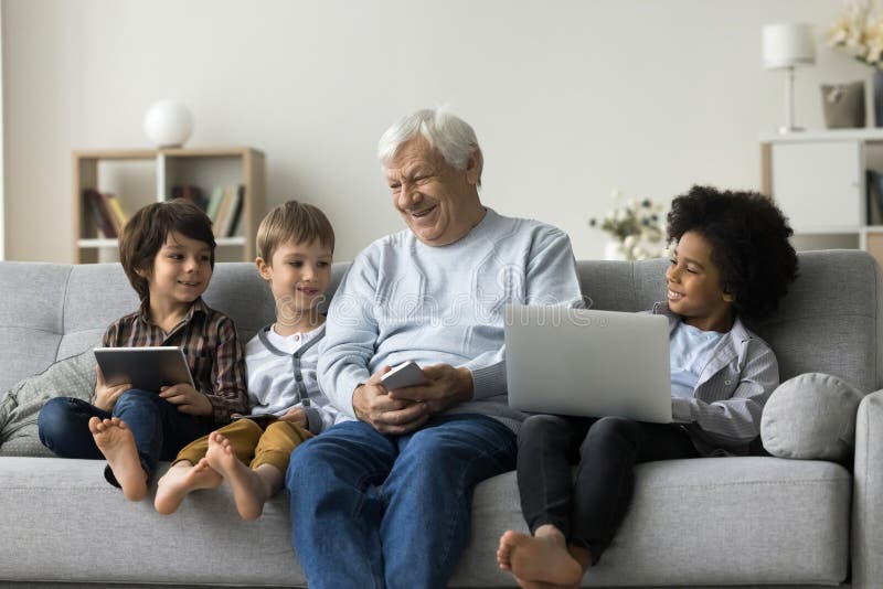 Great-grandpa and Great-grandsons Sit on Couch Holding Diverse Devices ...