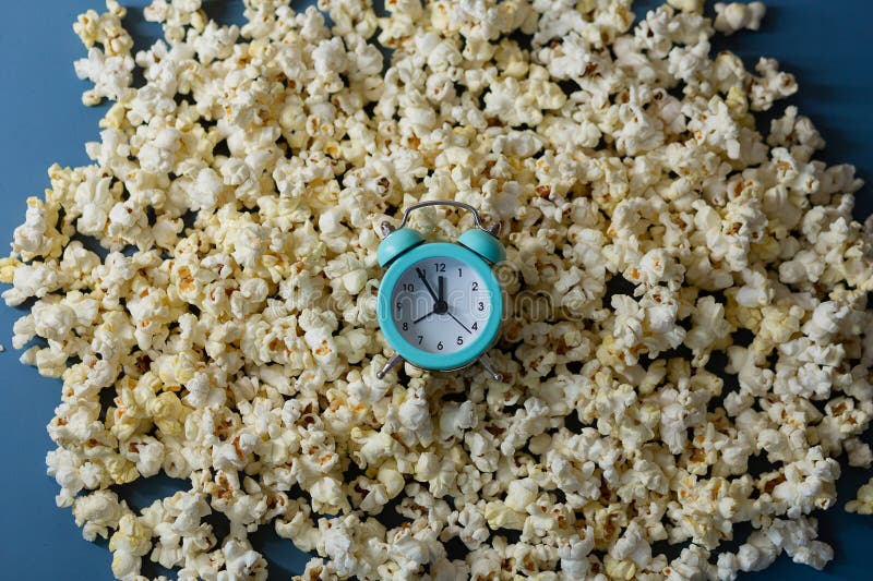 A Green Alarm Clock Lies in Clouds of Popcorn Stock Photo - Image of ...