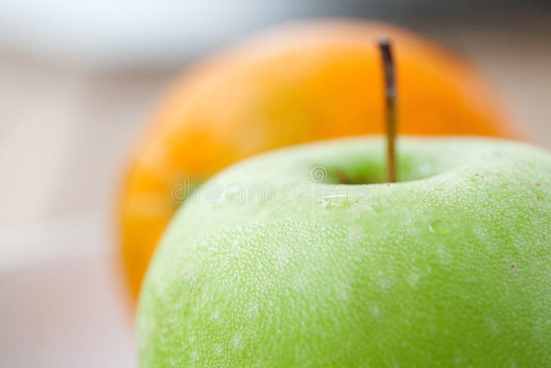 Green Apple with an Orange in the Back Stock Image - Image of apple ...