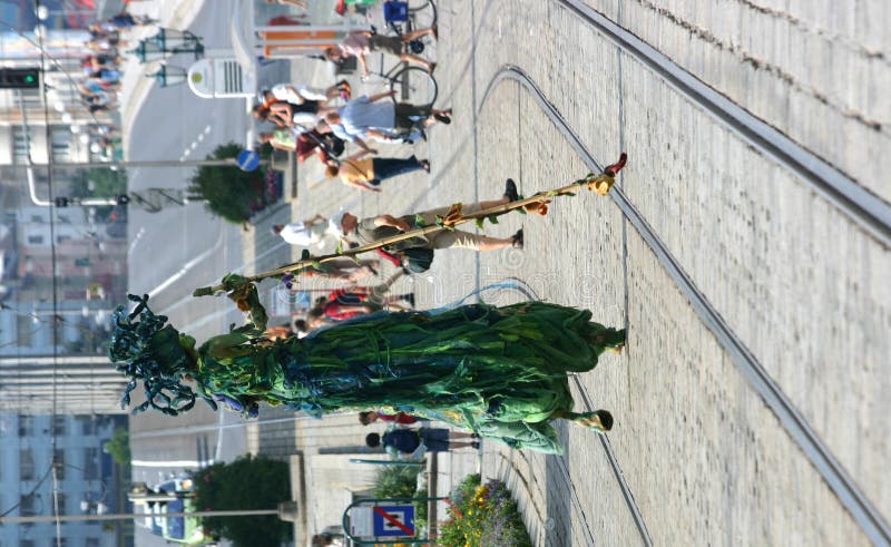 Green Artist on Stilts Walking Down the Street Stock Photo - Image of ...