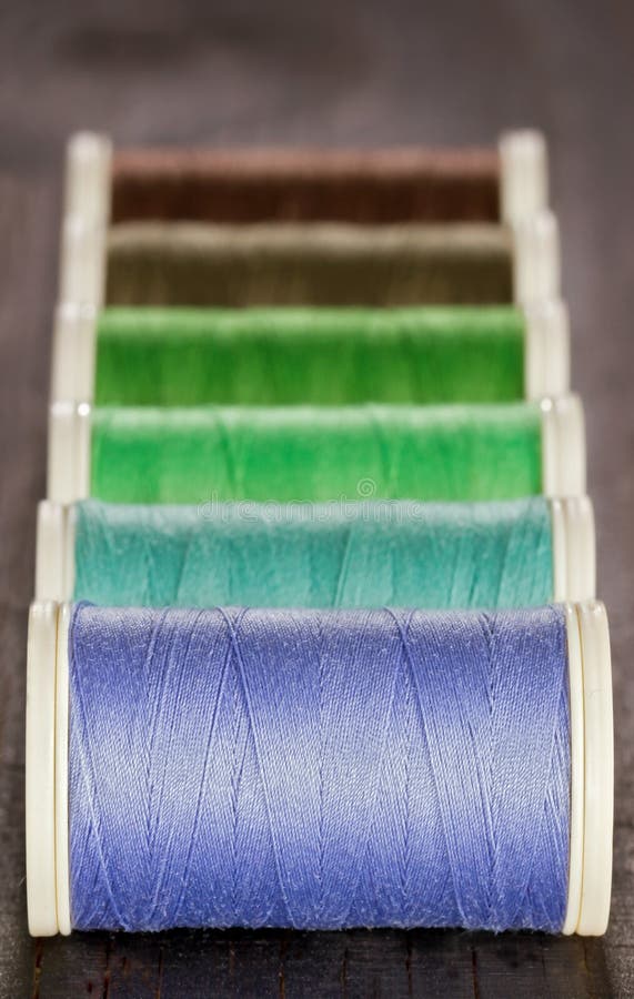 Green and Blue Spools of Thread on Dark Background Stock Image - Image ...