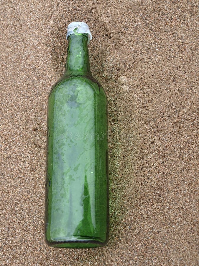 Green bottle on the sand stock image. Image of closeup - 22806127