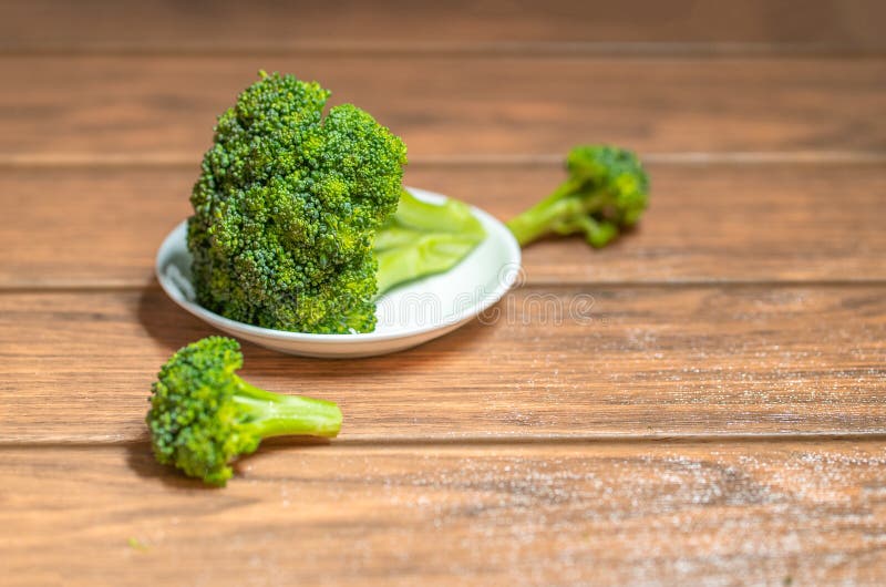 Green Broccoli on a Plate and Pieces of Broccoli Off the Plate Stock ...