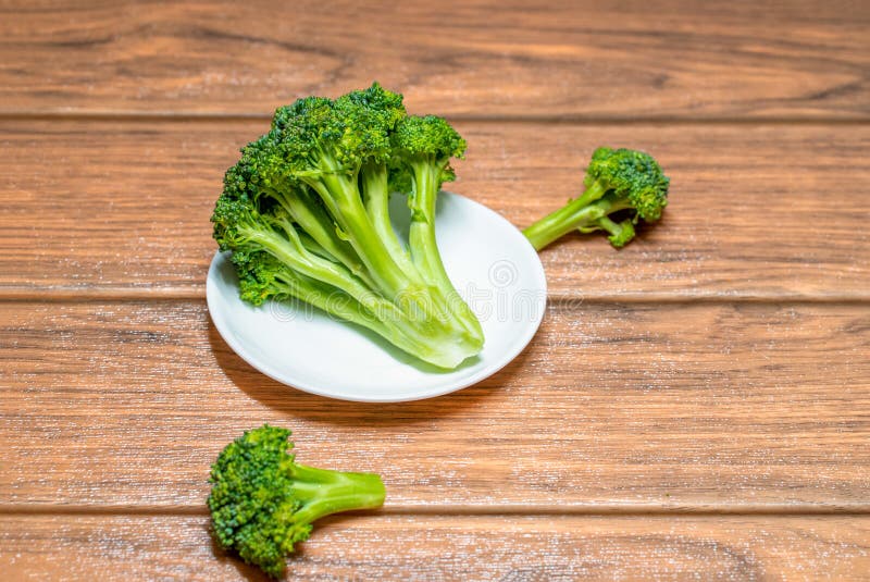 Green Broccoli on a Plate and Pieces of Broccoli Off the Plate Stock ...