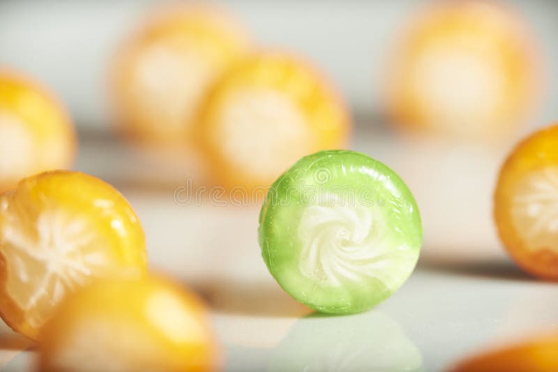 A Green Candy in the Middle of Many Orange Ones Stock Photo - Image of ...