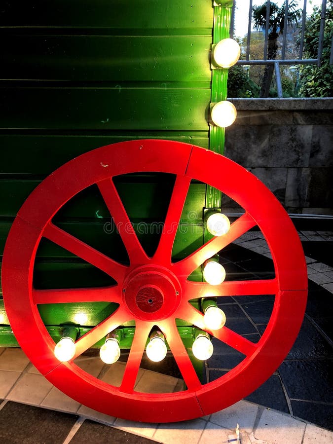 Green Carriage and Red Wheel with Flashing Lights. Stock Photo - Image ...