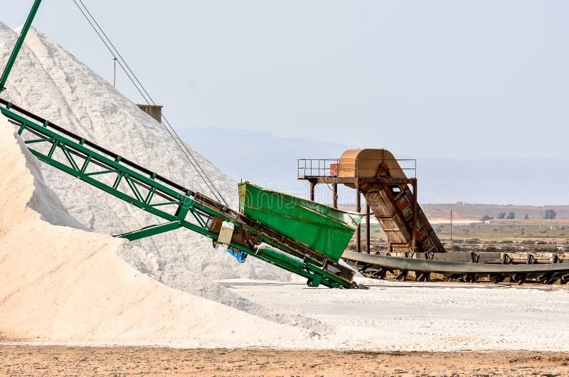 A Green Conveyor Belt is Pulling a Large Green Container of Salt Stock ...