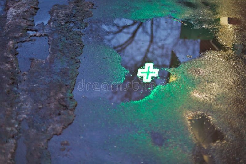 Green Cross Reflection in Rain Puddle Stock Image - Image of green ...