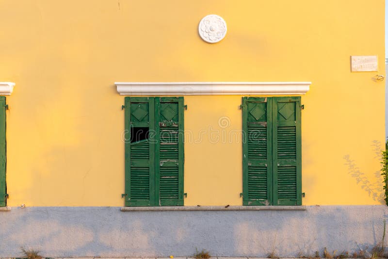 Green Double Louvre Doors in Poor Condition in Yellow Wall Stock Image ...