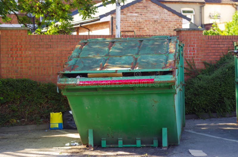 A Green Dumpster is Sitting in Front of a Brick Wall Stock Photo ...