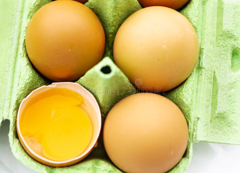 Green Egg Carton with Three Whole Eggs and One Broken Egg Yolk Stock ...