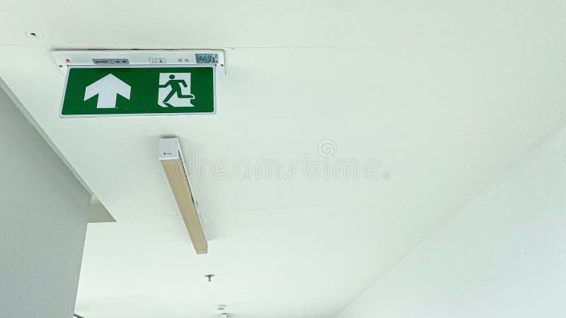 Green Emergency Exit Sign on Ceiling Stock Photo - Image of corridor ...