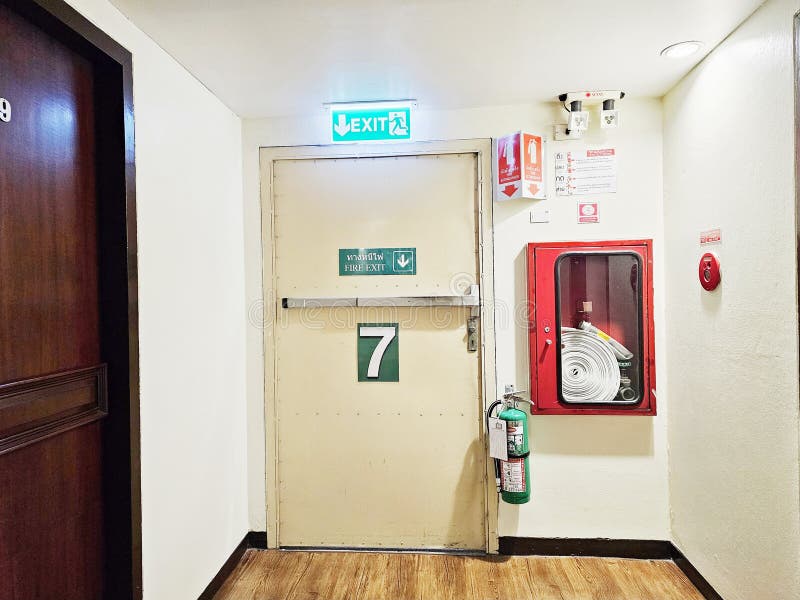 Green Emergency Exit Sign and Fire Extinguisher at Building. Fire Exit ...
