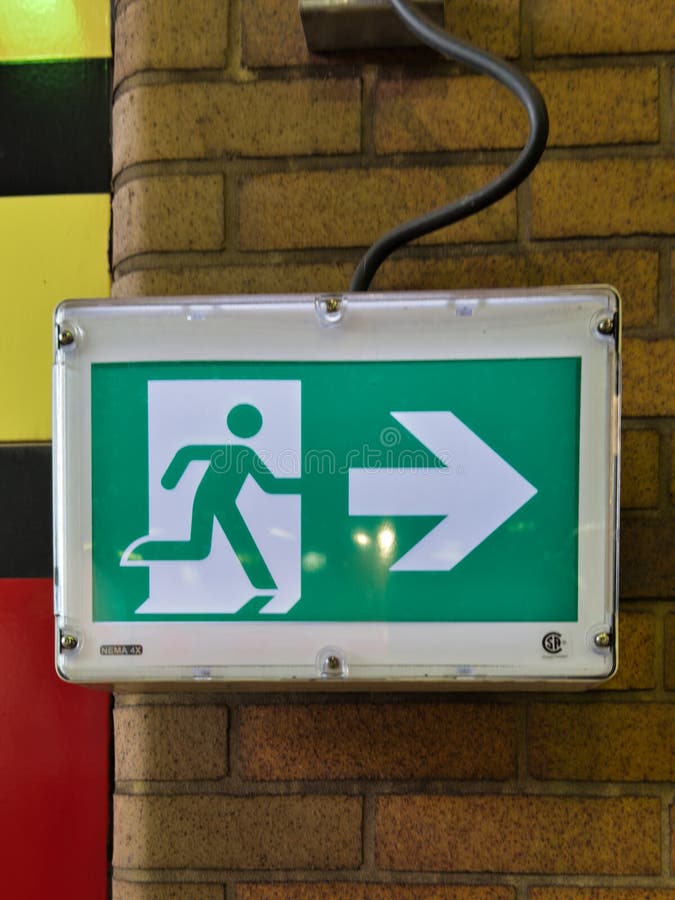 Green Emergency Exit Sign on Brick Wall Stock Photo - Image of ...