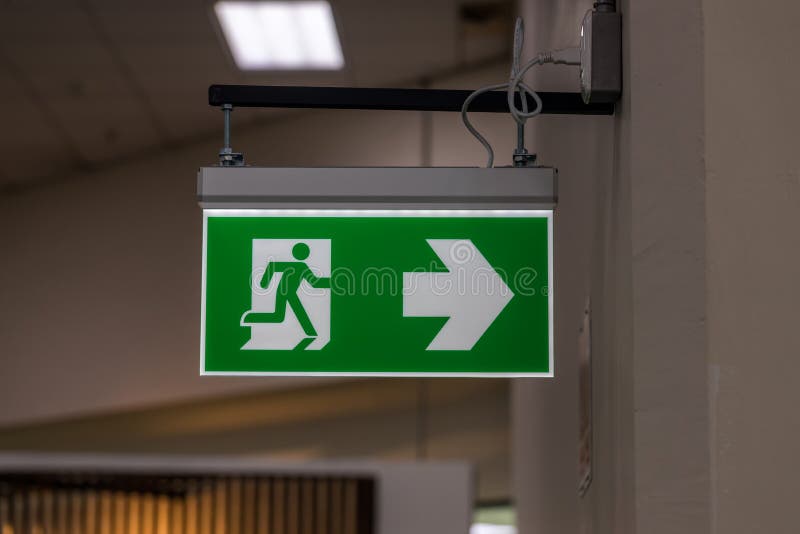 Green Emergency Exit Sign Showing the Way To Escape. Fire Exit in the ...