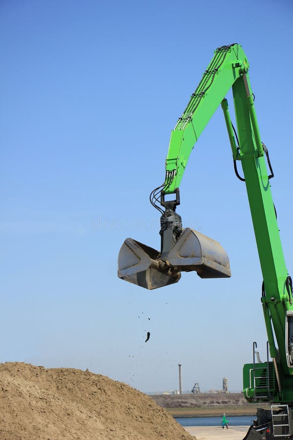 Excavator Scooping Dirt in Front of a Dramatic Sky Stock Photo - Image ...