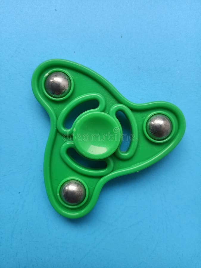 Green Fidget Spinner Device on Blue Background Stock Photo - Image of ...