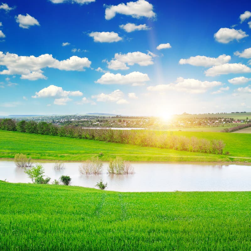 Green field, lake and sun stock image. Image of background - 76323483