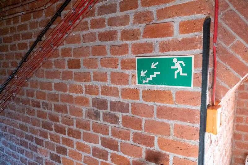 A Green Fire Exit Sign through the Staircase To the Bottom is Placed on ...
