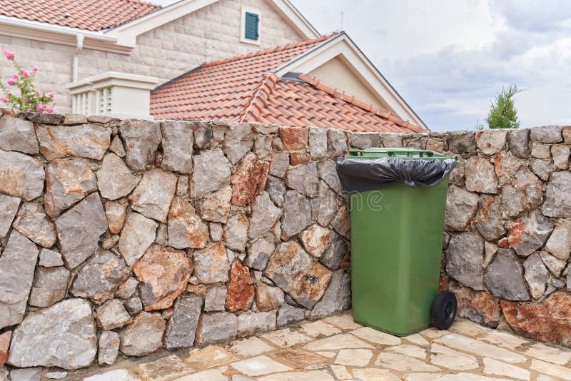 Green Garbage Bin Next To the House on Back Yard Stock Photo - Image of ...