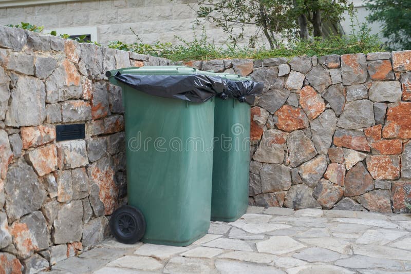 Green Garbage Cans Next To the Stone Wall Stock Image - Image of ...