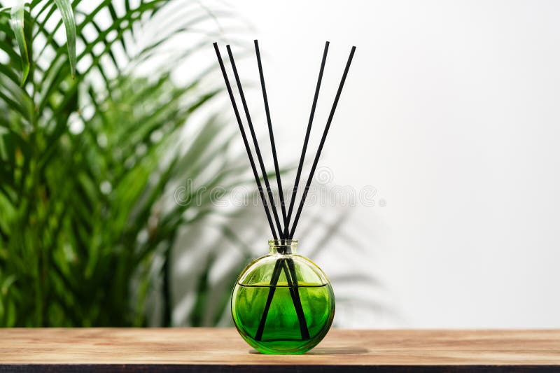 Green Glass Reed Diffuser on Wooden Tabletop with Greenery in ...