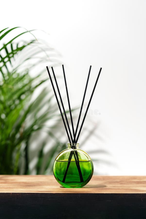 Green Glass Reed Diffuser on Wooden Tabletop with Greenery in ...