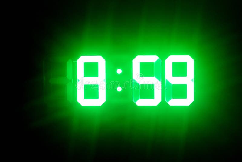 Green Glowing Digital Clocks in the Dark Show 8:59 Time Stock Photo ...