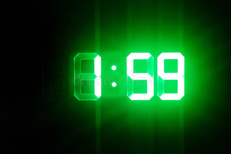 Green Glowing Digital Clocks in the Dark Show 1:59 Time Stock Image ...
