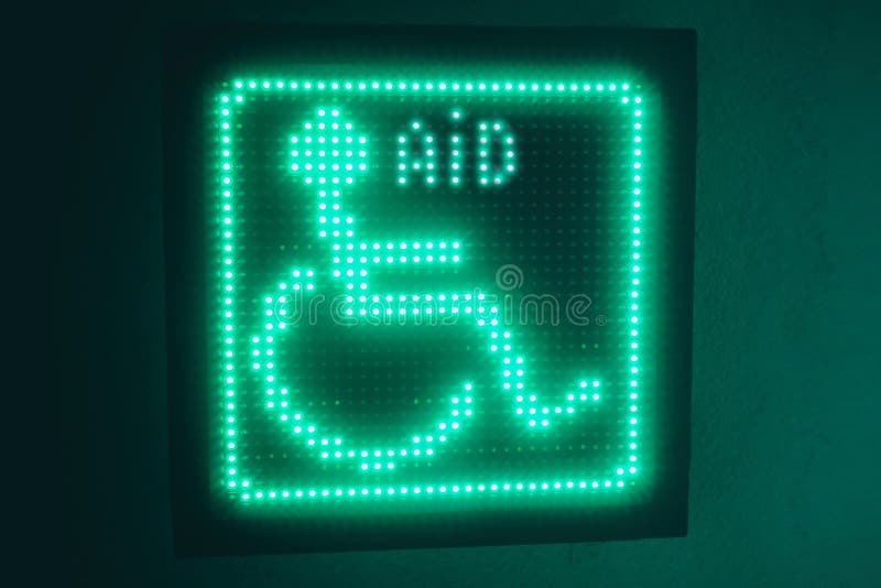 Green Glowing Symbol of the Disabled Hanging on the Wall Stock Image ...