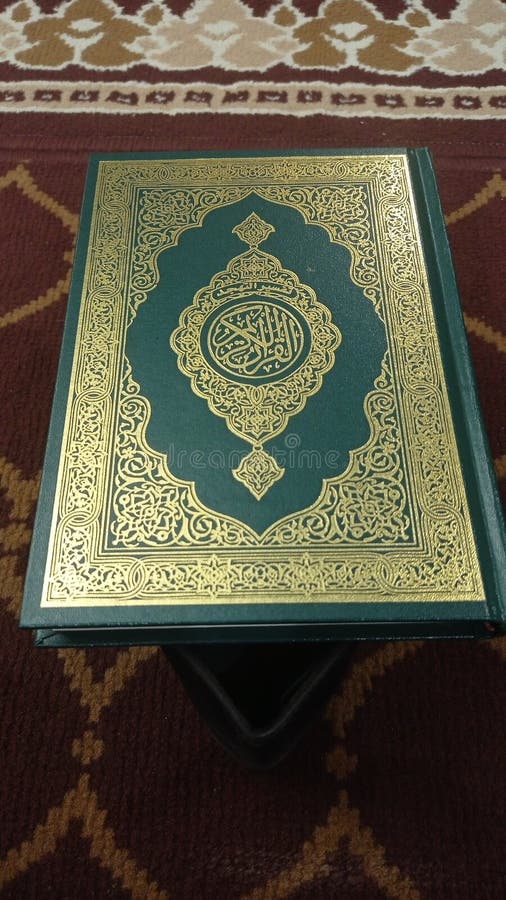 A Green and Gold Ornate Quran Rests on a Patterned Prayer Rug. Stock ...