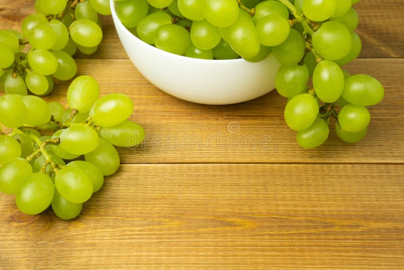 Green Grapes in White Ceramic Bowl on Wooden Table with Empty Space ...