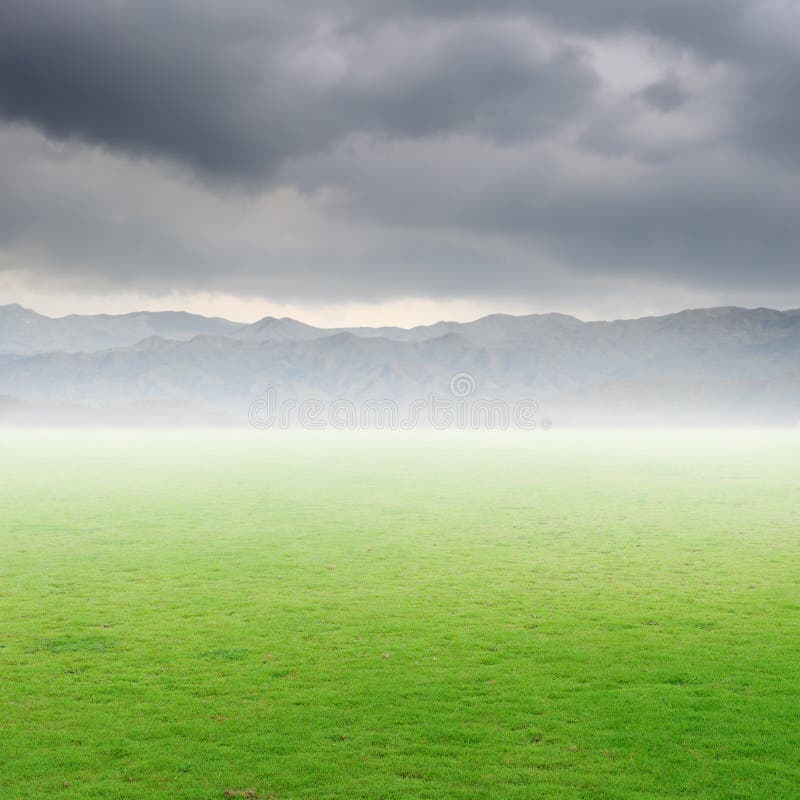 Green Grass Field and Rainclouds Mountain for Background Stock Photo ...