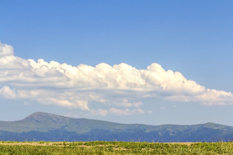 Green Grass Meadow and Distant Blue Mountains Stock Image - Image of ...
