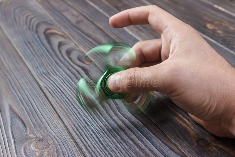 Green Hand Spinner, or Fidgeting Spinner, Rotating on Man S Hand Stock ...