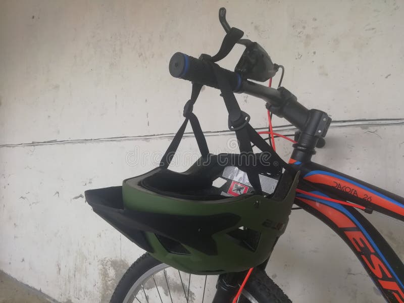 A Green Helmet Hanging from a Bicycle Handle Stock Photo - Image of ...