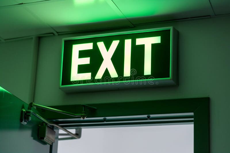 Green Illuminated Exit Sign Above an Open Door, Indicating a Safe Route ...