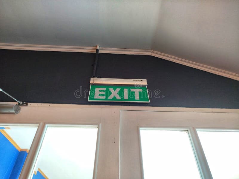 Green Illuminated Exit Sign Above White Door Stock Photos - Free ...