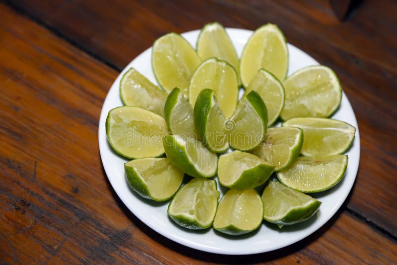 Green lemons cut in bowl stock image. Image of citric - 322174479