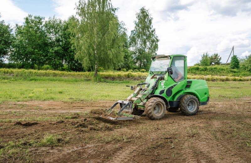 A Green Mini Skid Steer Loader Clear the Construction Site. Land Work ...