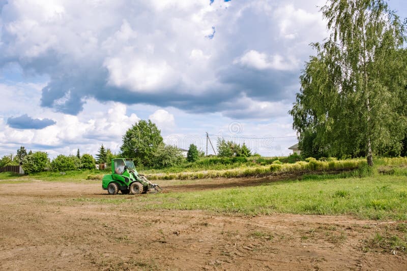 A Green Mini Skid Steer Loader Clear the Construction Site. Land Work ...