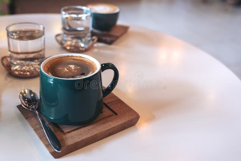 Green Mugs of Hot Coffee and Glasses of Water on Table in Cafe Stock ...
