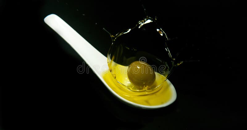 Green Olive, Olea Europaea, Falling in a Spoon Against Black Background ...