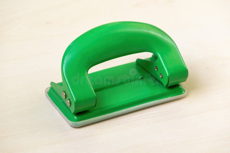 Green Paper Hole Puncher or Punch Machine on a Light Wooden Backdrop ...