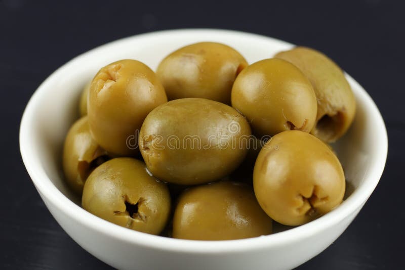 Green Pitted Olives in a White Plate. White Plate with Delicious Pitted ...