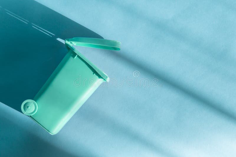 A Green Plastic Garbage Bin on Blue Background, Great for Recycling ...