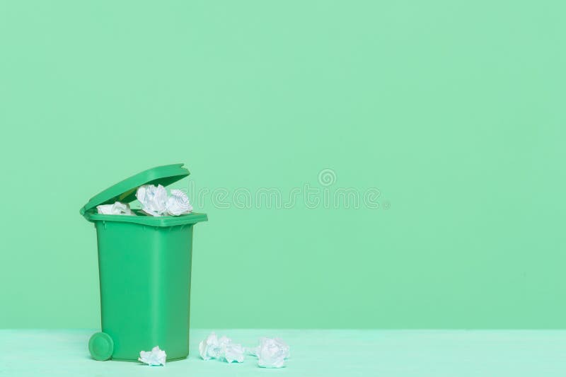 A Green Plastic Garbage Bin and Paper on Green Background, Great for ...