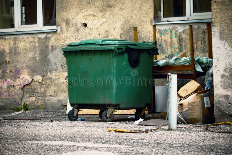 Green Garbage Container with Open Cover Standing Outdoors on Dry Sandy ...