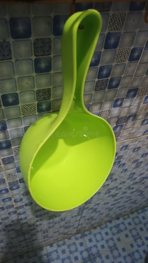 Green Plastic Measuring Spoon on Tiled Wall Stock Photo - Image of ...